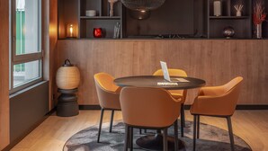 Uma área de refeições moderna com uma mesa redonda, quatro cadeiras e um lustre.