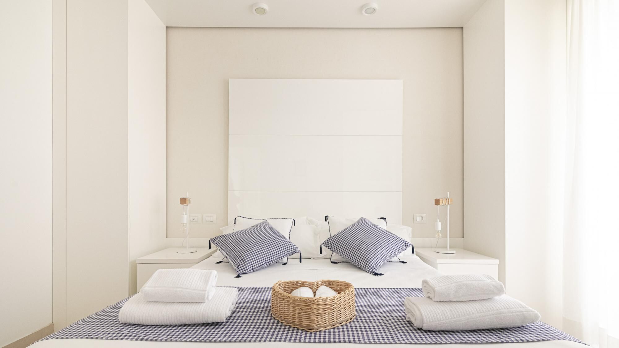 Um quarto moderno com uma cama grande, duas mesas de cabeceira e uma cabeceira.