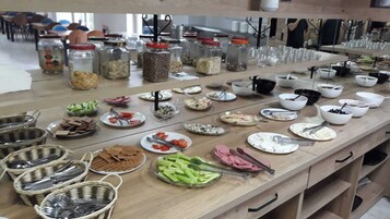 Uma mesa de buffet com diversos alimentos e utensílios.