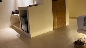 Quarto moderno e minimalista com escrivaninha embutida, luminária pendente e guarda-roupa de madeira.