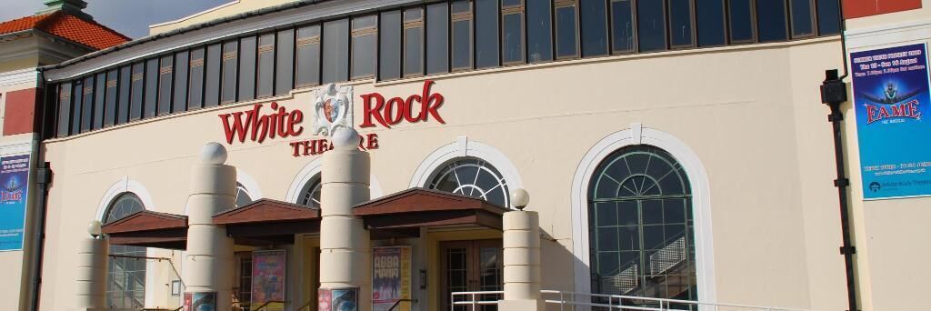 Um teatro com uma placa indicando 'White Rock Theatre'.
