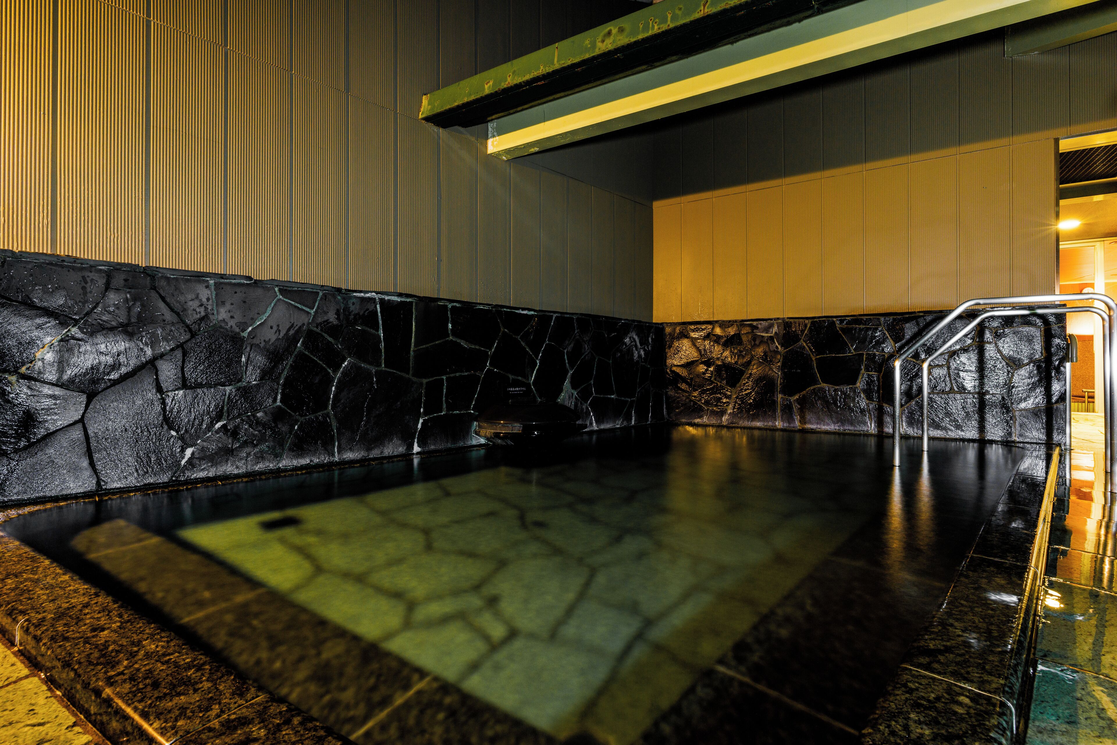 Uma área de spa com parede de pedra e piscina.