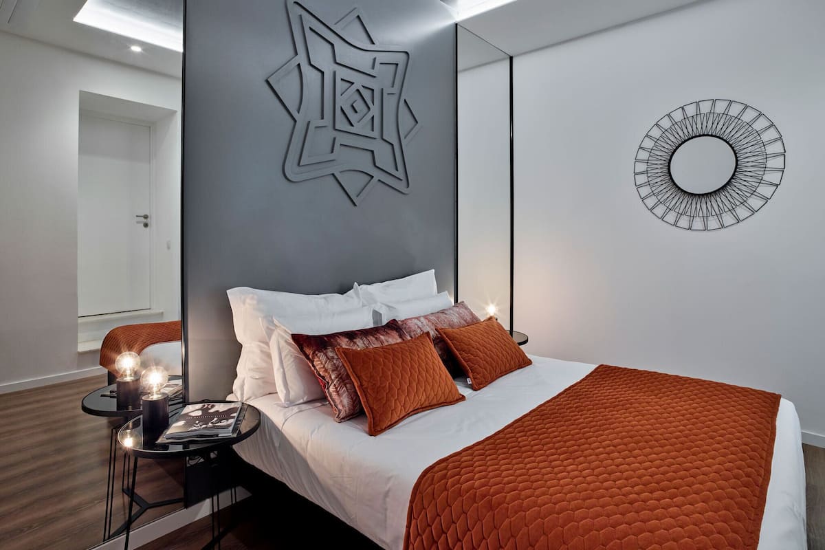 Um quarto moderno com uma cama, uma mesa de cabeceira e uma obra de arte na parede.