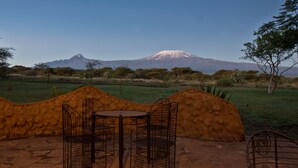 Mesa e cadeiras montadas em frente a uma parede com vista para a montanha.