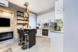 Apartamento Deluxe | Sala de estar | Televisor de ecrã plano de 58 cm com canais por cabo, televisor 