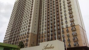 Um edifício residencial alto com várias varandas e uma placa na base com o nome