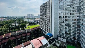 Um edifício residencial alto com várias varandas e um pátio verde.