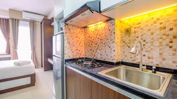 Um frigorífico, uma placa de cozinha, utensílios de cozinha