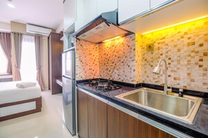 Uma cozinha moderna com fogão a gás, pia de aço inoxidável e painel de azulejos.
