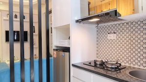 Uma cozinha moderna com geladeira de aço inoxidável, fogão a gás e painel de parede estampado.