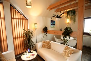 Uma sala de estar moderna com um sofá, uma mesa de centro e um vaso de plantas.