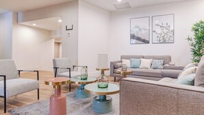 Uma sala de estar moderna com um sofá, poltronas e uma mesa de centro.