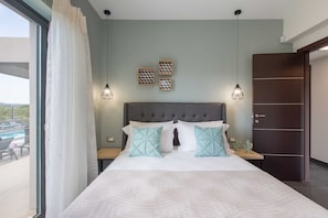 Quarto com cama grande, duas mesas de cabeceira, encosto e vista para piscina.