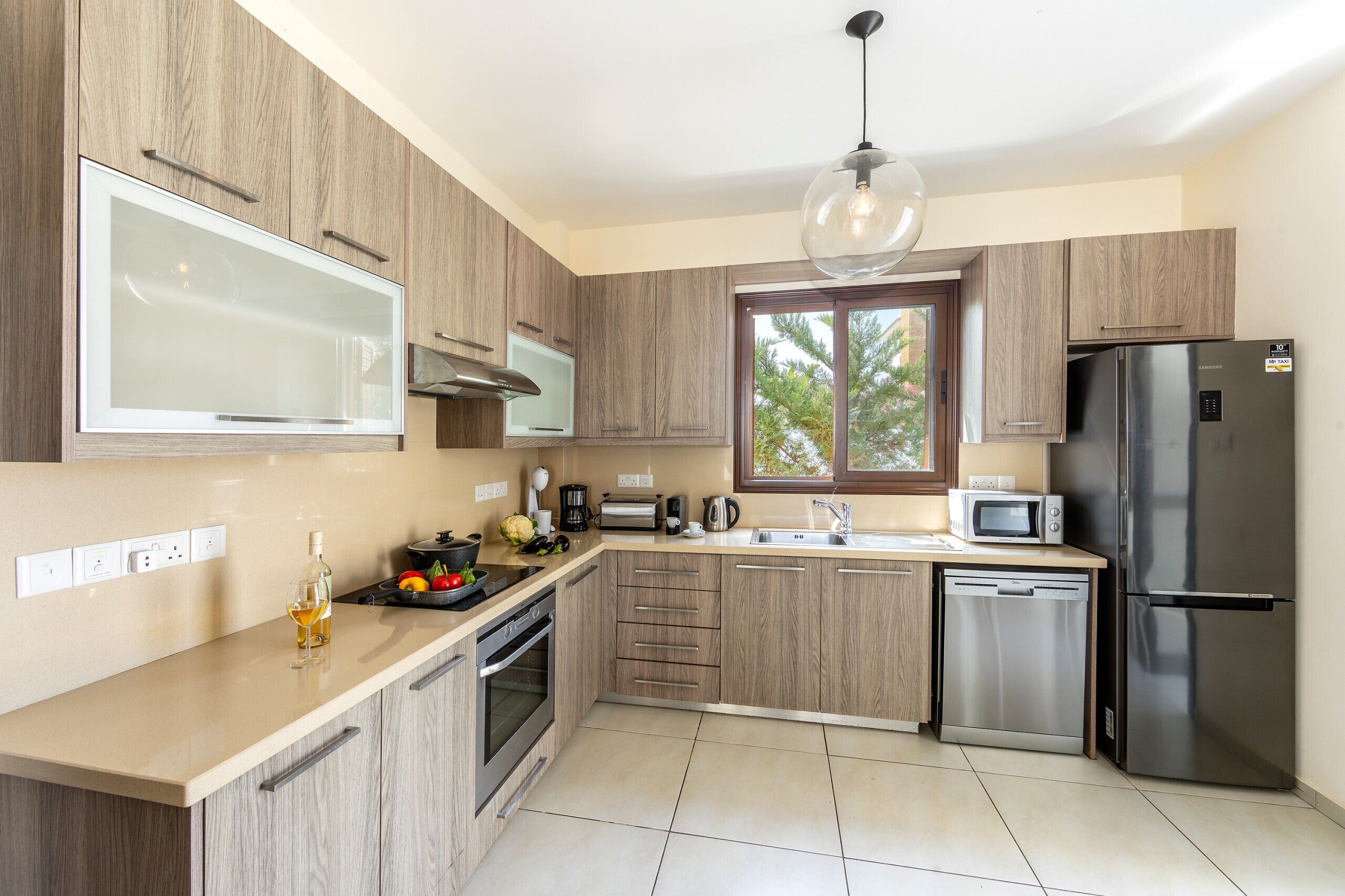 Uma cozinha moderna com armários de madeira, eletrodomésticos de aço inoxidável e uma janela grande.