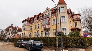 Um edifício de vários andares com estilo arquitetônico tradicional, destacando uma torre imponente e sacadas.