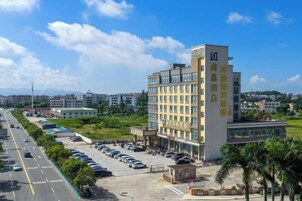 Hotel com vários andares e estacionamento em frente.