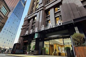 Hotel com fachada moderna, grandes janelas e entrada visível.