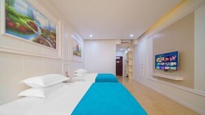 Quarto de hotel com duas camas, televisão na parede e obras de arte nas paredes.