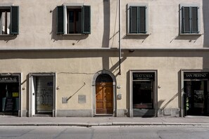 Fachada de edifício com três lojas: EBY'S, TRATTORIA e SAN PIERINO.