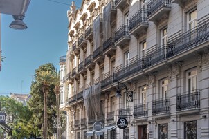 Um edifício histórico com varandas ornamentadas e uma placa com o nome 'Conchely Marigold Hotel'.
