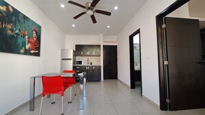 Cozinha moderna com armários escuros, micro-ondas e ventoinha no teto.