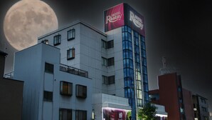 Um hotel com uma placa bem visível, uma grande área envidraçada e uma varanda aparente.