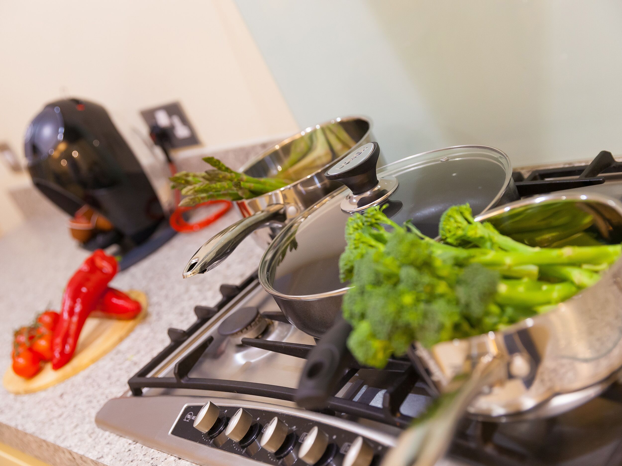 Cozinha com eletrodomésticos de aço inoxidável, incluindo fogão e panelas.