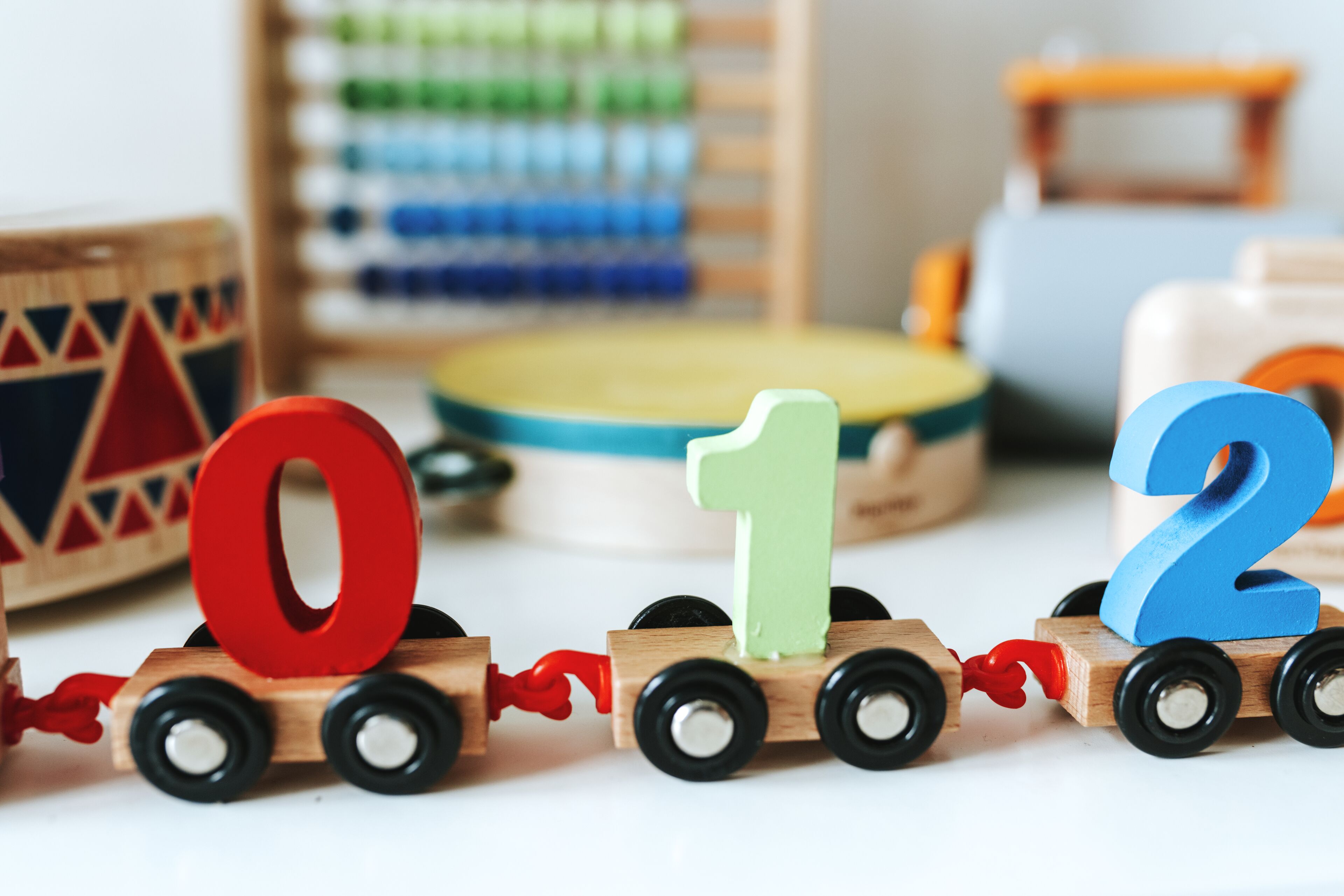 Um trem de brinquedo de madeira com vagões numerados.