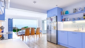 Uma cozinha moderna com uma ilha grande, uma área de refeições com vista e um forno embutido.