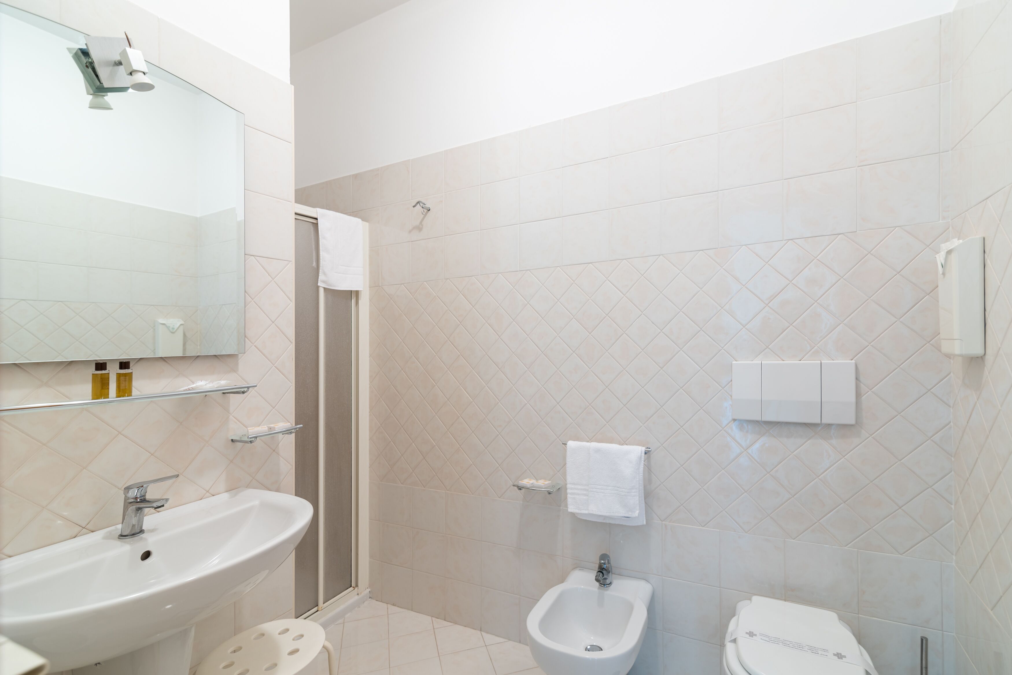 Uma casa de banho moderna com lavatório, bidé e sanita.