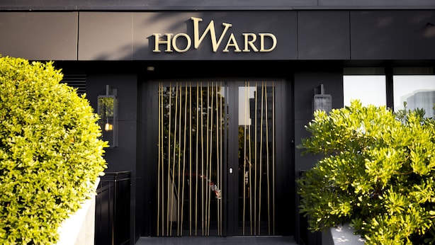 Entrada de um edifício moderno com uma placa que diz 'HOWARD'.