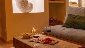 Uma sala de estar aconchegante, com uma mesa de centro de madeira, um sofá e arte decorativa na parede.