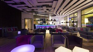 Uma área de estar moderna, com assentos, bar e vista para a cidade.