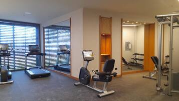 Uma academia com esteiras, bicicleta ergométrica e aparelhos de musculação.