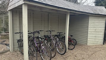 Abrigo para bicicletas coberto com várias bicicletas estacionadas lá dentro.