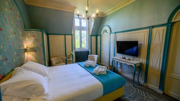 Quarto de hotel com cama, televisão, janela e banheiro.
