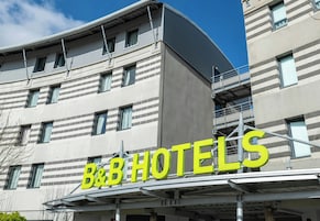 Um hotel B&B com design moderno, com uma placa de destaque e fachada curva.