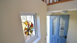 Uma porta azul com um painel de vidro e uma janela de vitrais com design circular.