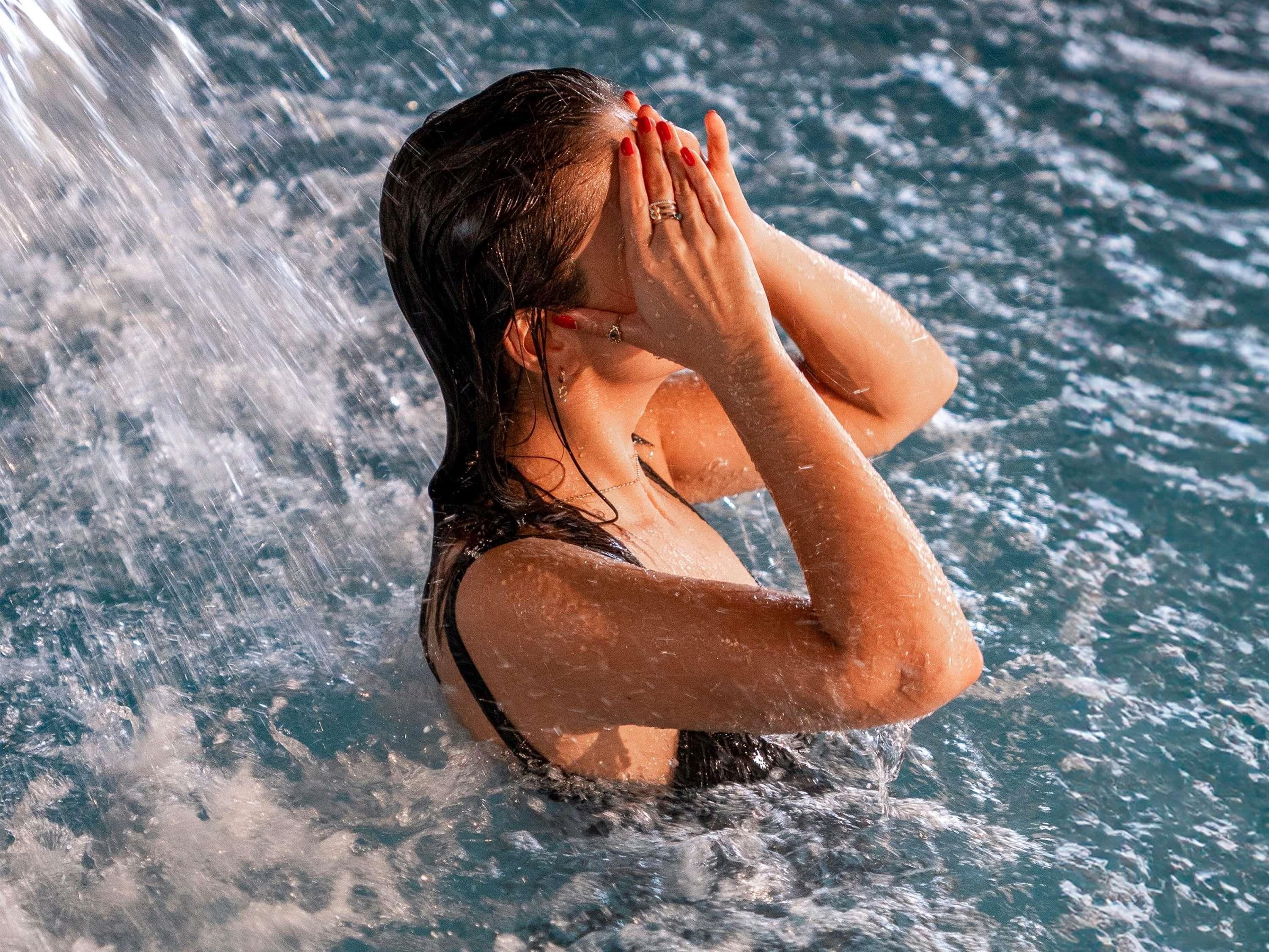 Alguém em uma piscina, com água espirrando ao redor.