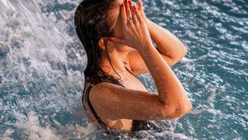 Alguém em uma piscina, com água espirrando ao redor.