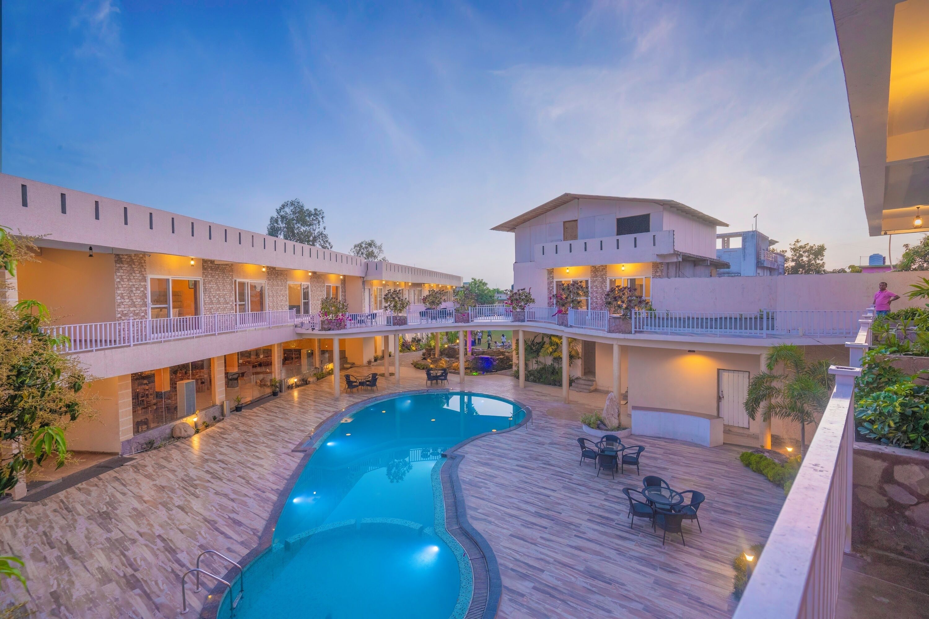 Um hotel com piscina, área de estar externa e várias varandas.