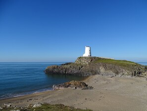 Um farol numa falésia rochosa à beira-mar.