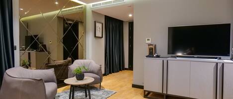 Uma sala de estar moderna com um sofá, uma poltrona e uma mesinha com uma planta.