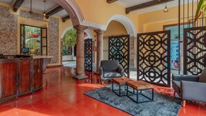 Um hall de entrada com balcão de recepção, área de estar e painéis decorativos.