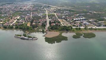 Vista aérea de uma cidade costeira com um porto de recreio, áreas residenciais e uma ponte ao fundo.