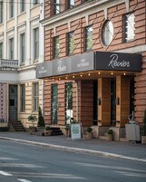 Um edifício de tijolos com uma placa indicando o restaurante e cinema 'Revier'.