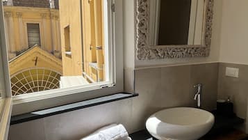 Apartamento família | Banheiro | Chuveiro, chuveiro com efeito de chuva, secador de cabelo, bidê