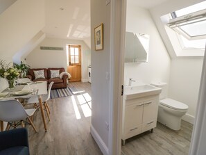 Um apartamento moderno com área de refeições, sala de estar e banheiro.