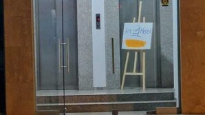 Exterior do Art Hotel, com design moderno, apresentando duas portas de vidro e uma placa.