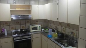 Cozinha compacta com fogão, micro-ondas e pia.